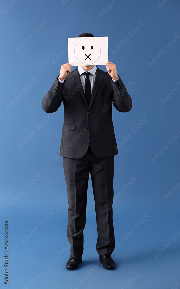 Businessman hiding face behind sheet of paper with drawn emoticon on ...