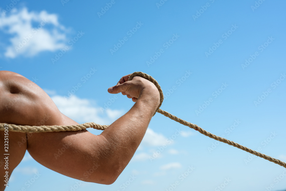 Gaining muscle. Sport training. Strong arm and shoulders tugging rope ...