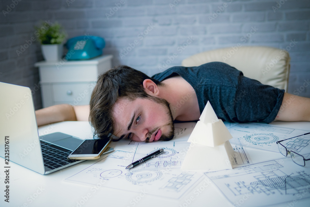 Engineering man working overwork and sleep on the desk with blueprint ...