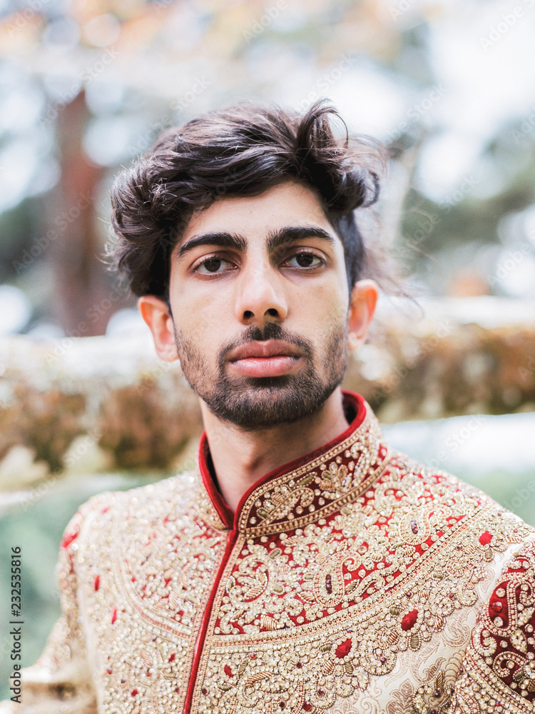 Portrait of an indian groom wearing traditional indian wedding costume ...
