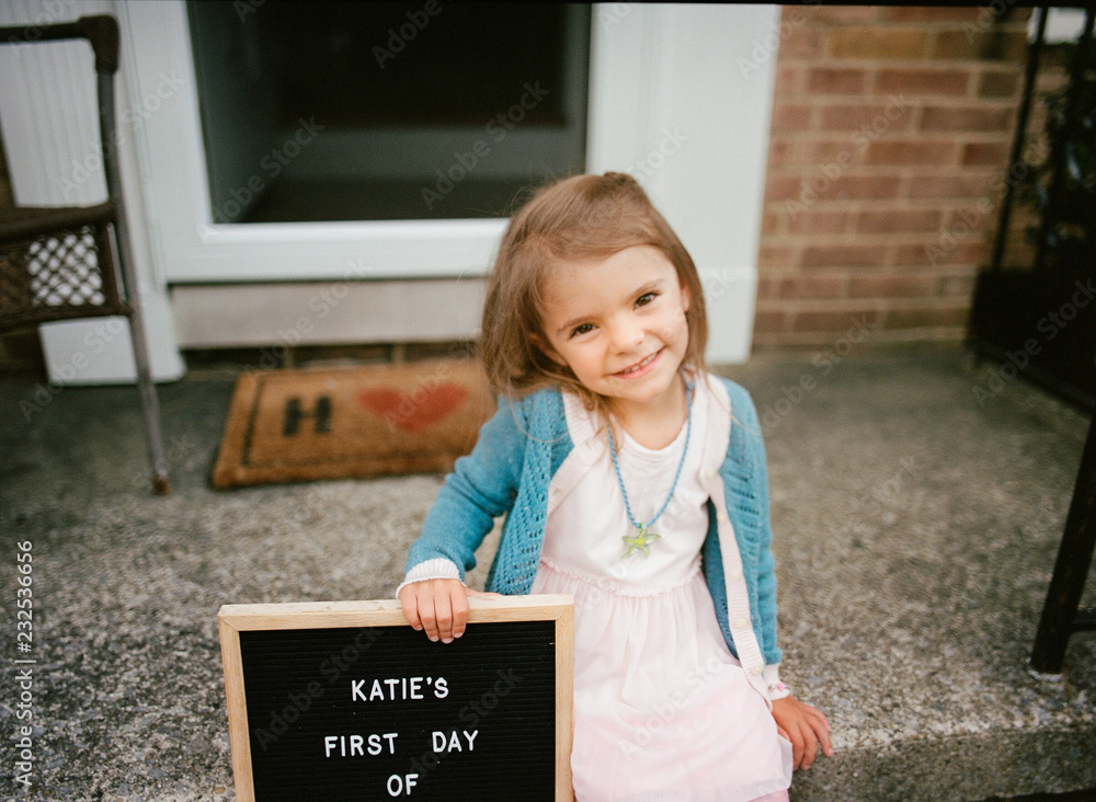 little girl with first day of school sign Stock Photo | Adobe Stock