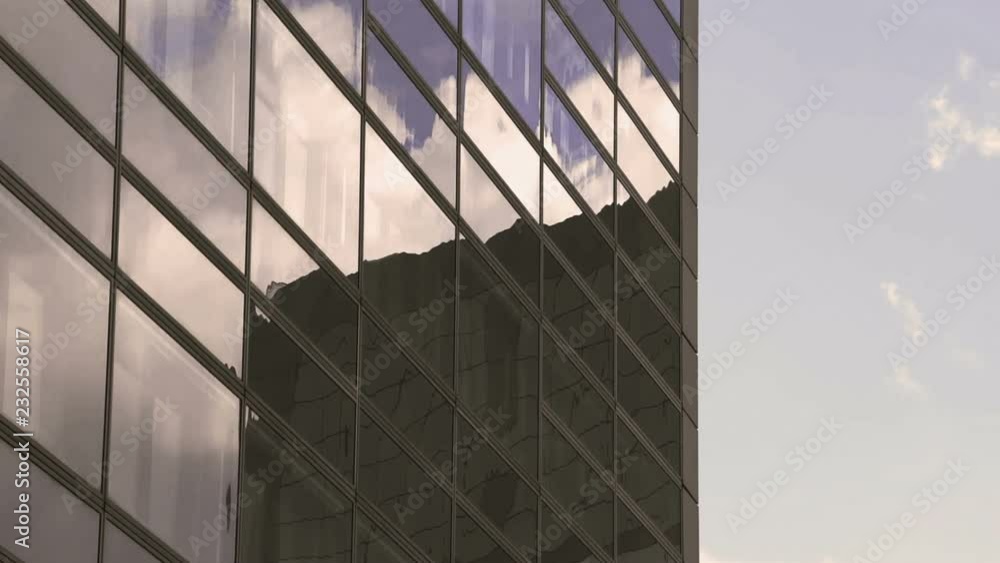 Glass facade of skyscraper building against blue sky and clouds ...