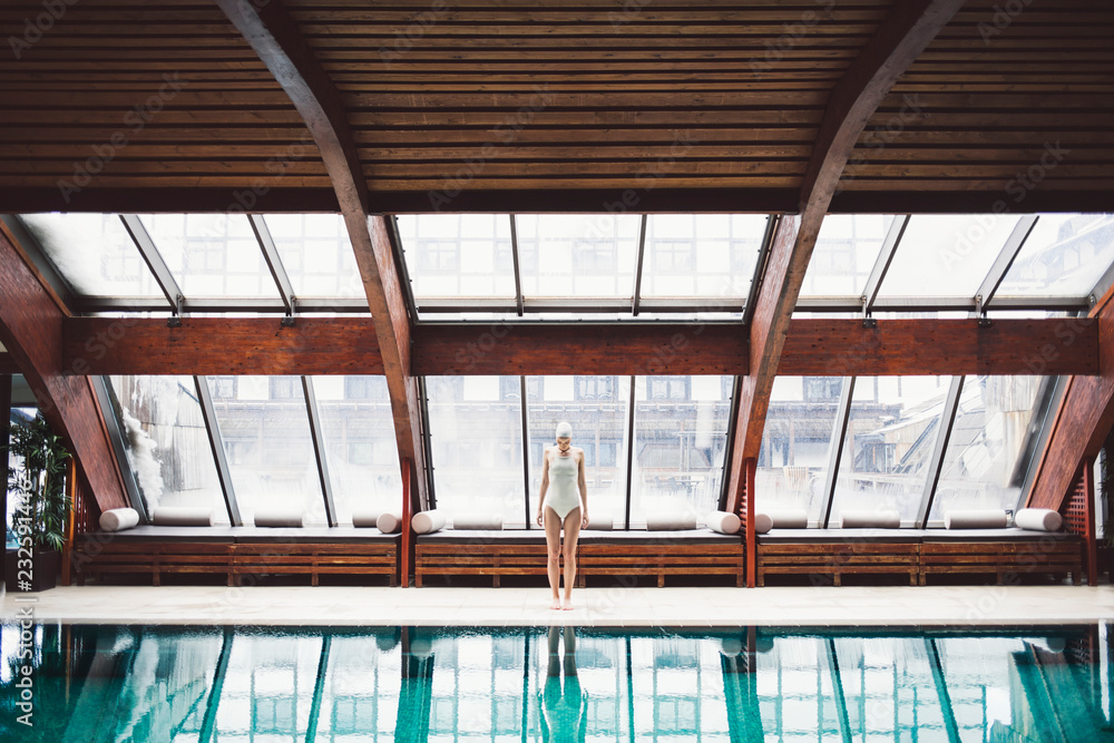 Woman Standing By The Swimming Pool Stock Photo | Adobe Stock