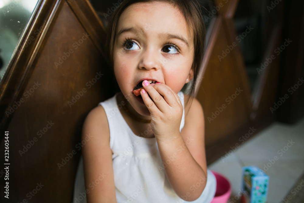 Cute little girl eating snack inside Stock Photo | Adobe Stock