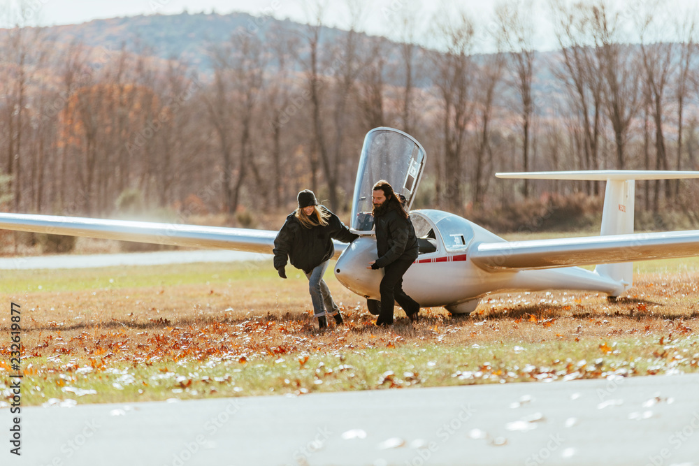 Friends dragging a glider plane to the runway before flight Stock Photo ...