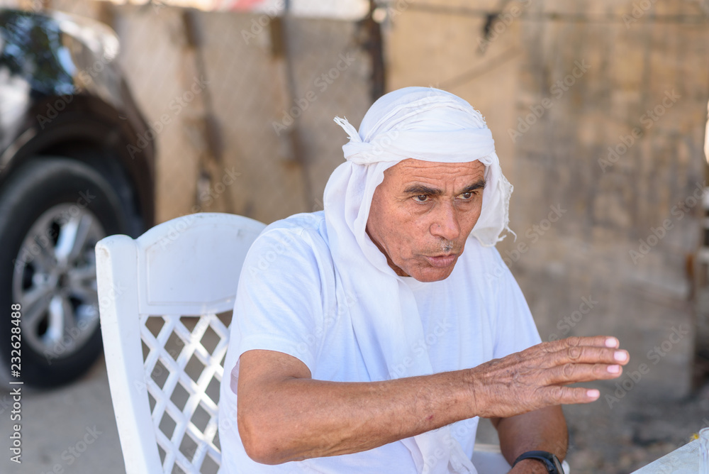 Old Arabic man in traditional clothes outdoor portrait. Serious Muslim ...