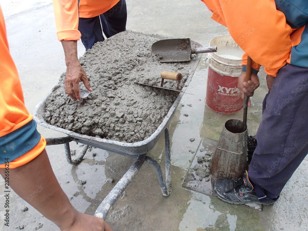 Construction workers doing slump test using specific equipment at the ...