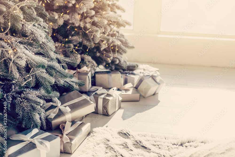 New Year's gold gifts lie under the Christmas tree. Large gift boxes ...