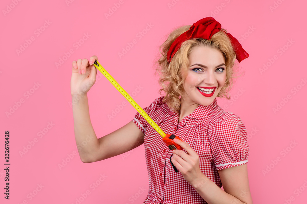Woman in pin-up style holds ruler. Pin-up girl holds construction ruler ...
