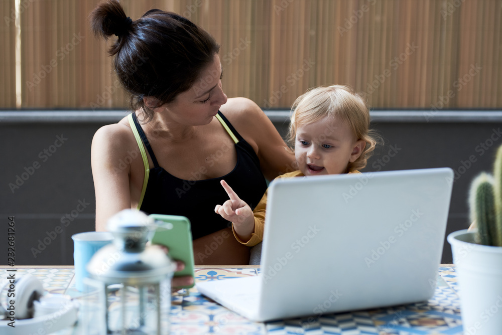 Mother and baby girl at computer. Stock Photo | Adobe Stock