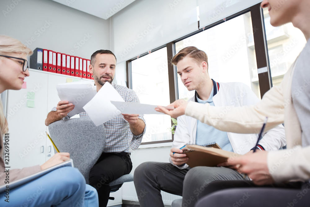 Students passing over papers with their ideas to teacher at the end of ...