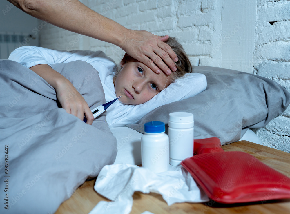 Little girl lying sick in bed feeling sick having a cold flu symptoms ...