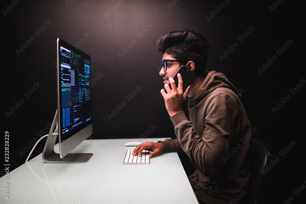 cybercrime, hacking and technology concept. Indian man hacker talk ...