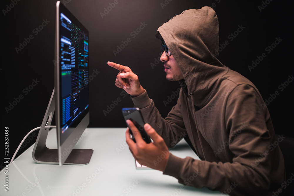 cybercrime, hacking and technology concept. Indian man hacker with ...