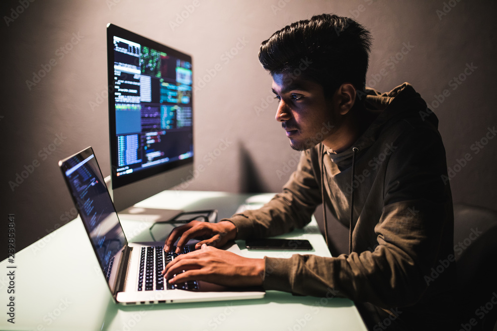 Program development concept. Young indian man working with computer in ...