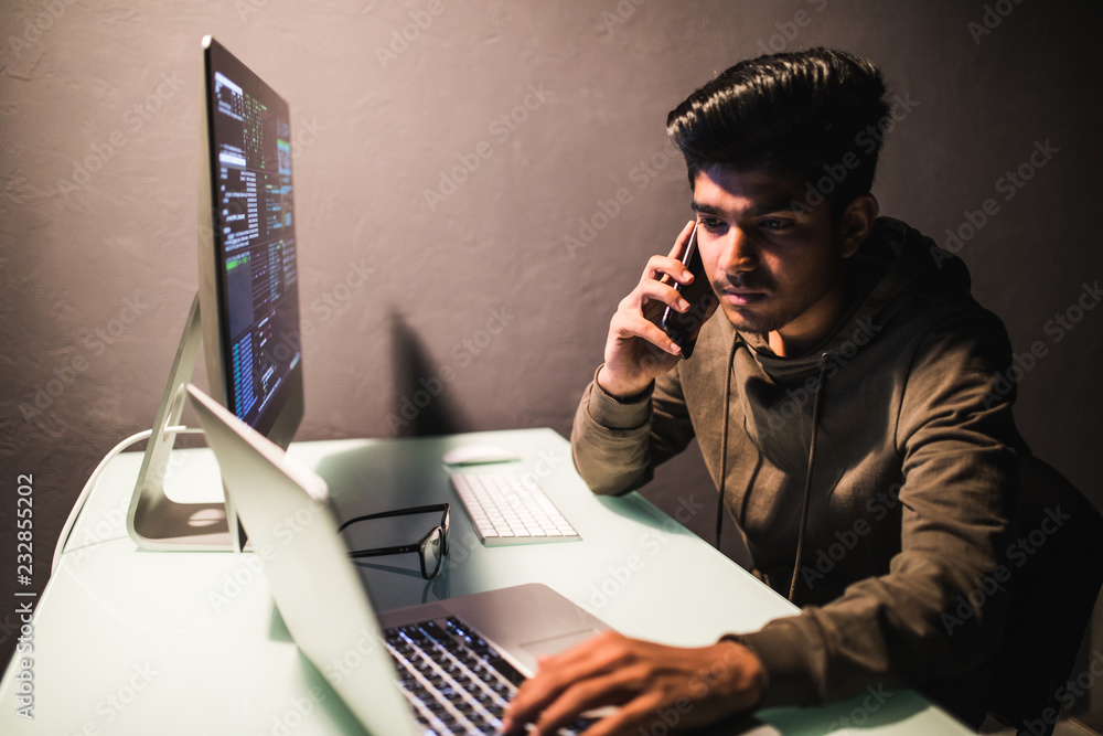 Cybercrime, hacking and technology concept. Indian male hacker with ...