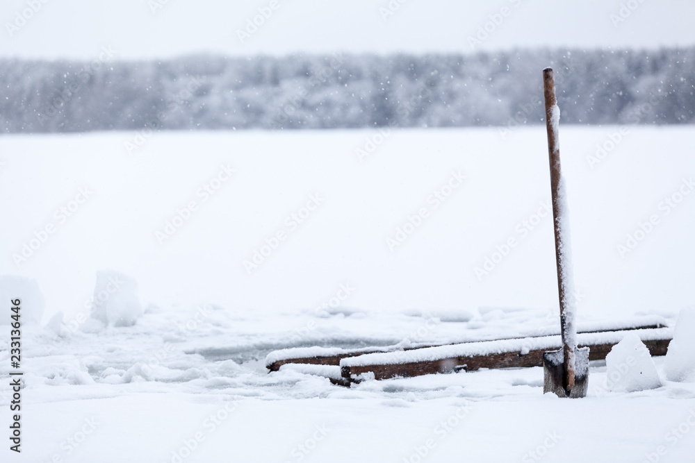 Grafting spade stick into ice. Making ice-hole for winter swimming in ...