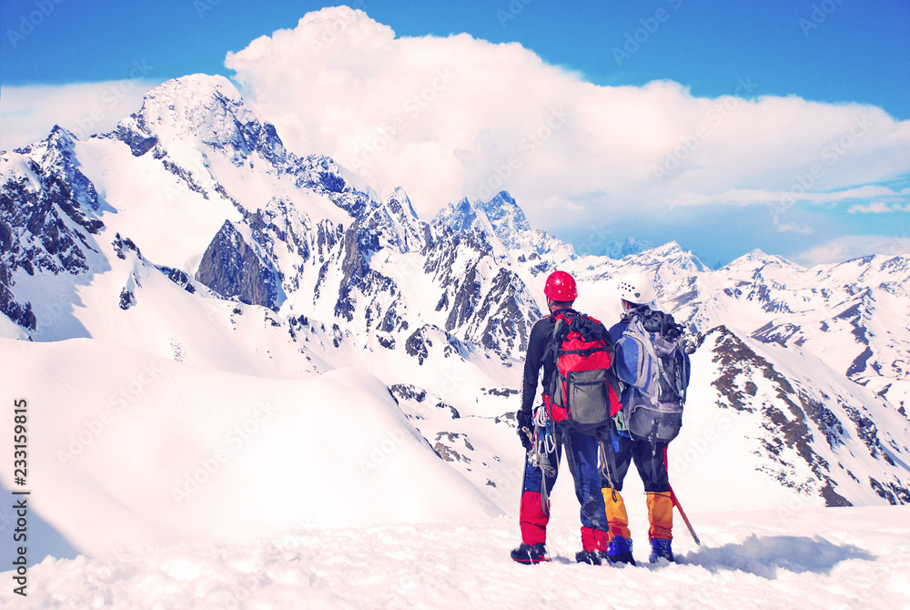Group of climbers reach the top of mountain peak. Climbing and ...