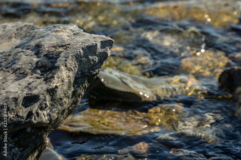 Sea stones and rocks of different sizes and texsture of black, gray and ...