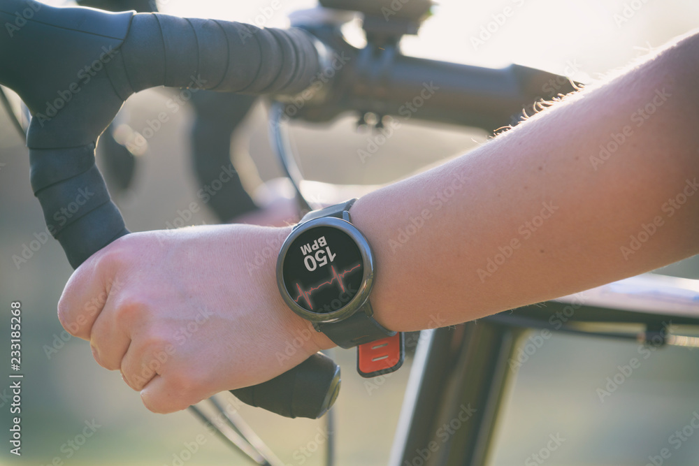 Woman riding a bike with smartwatch heart rate monitor Stock Photo ...