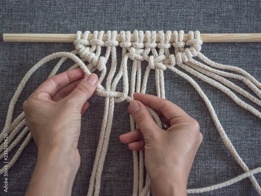 Macrame. Girl weaves macrame. White thread, female hand, grey ...