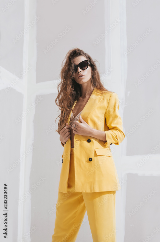 Young Female Fashion Model In Abstract White Space With Yellow Outfit