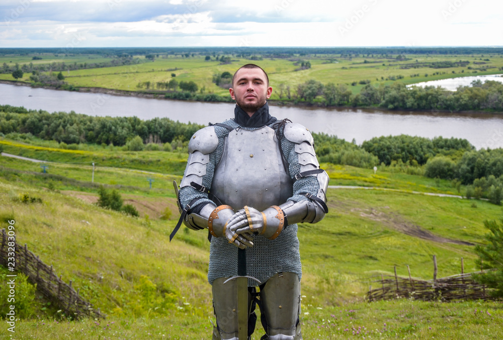 knight in armor stands against the background of native open spaces ...