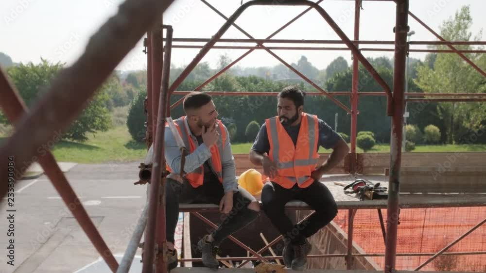 People working in construction site. Two happy men laughing at work in ...