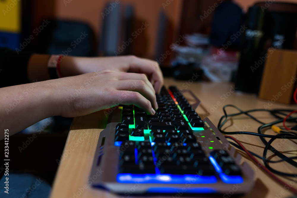 Caucasian boy playing video games , gamer keyboard, focus on the boys ...