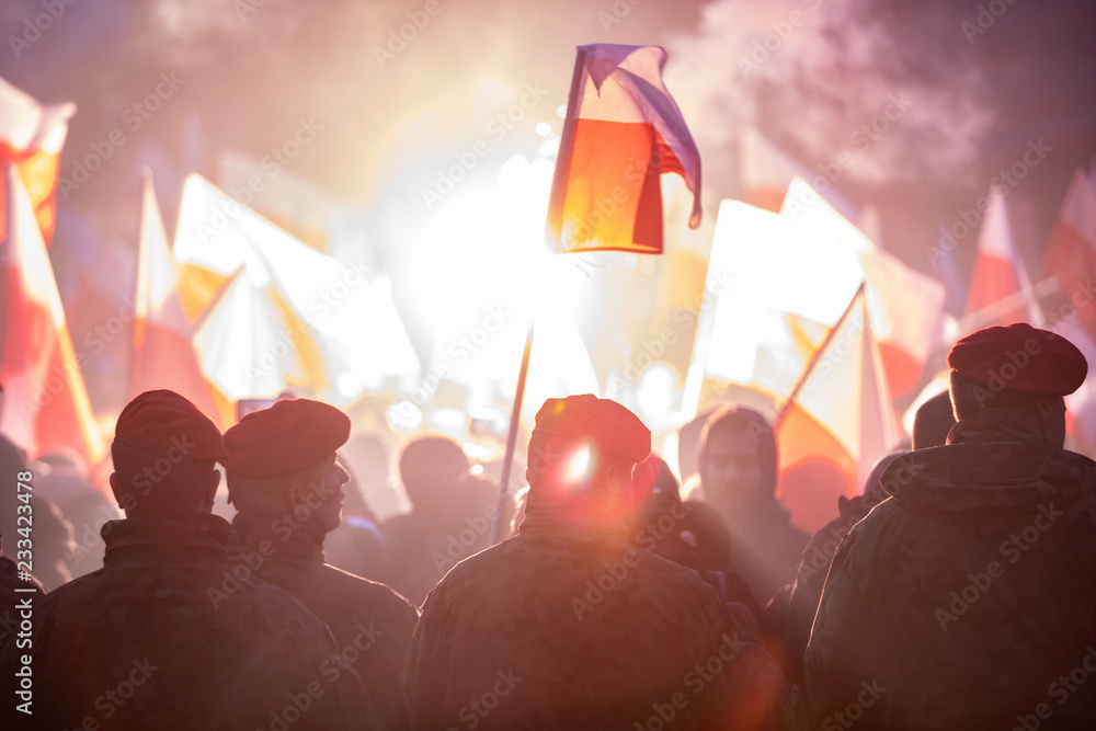 People carry Polish flags and burn flares as they walk across the ...