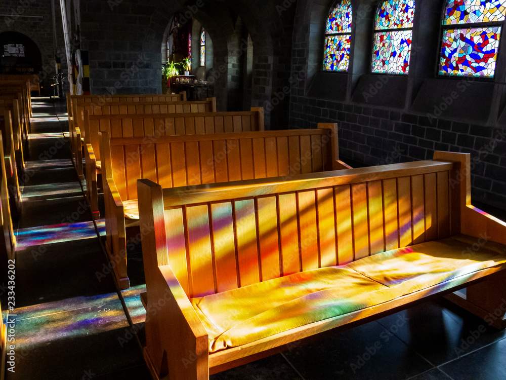 Beautiful colorful sunlight window reflections on the pews of the ...