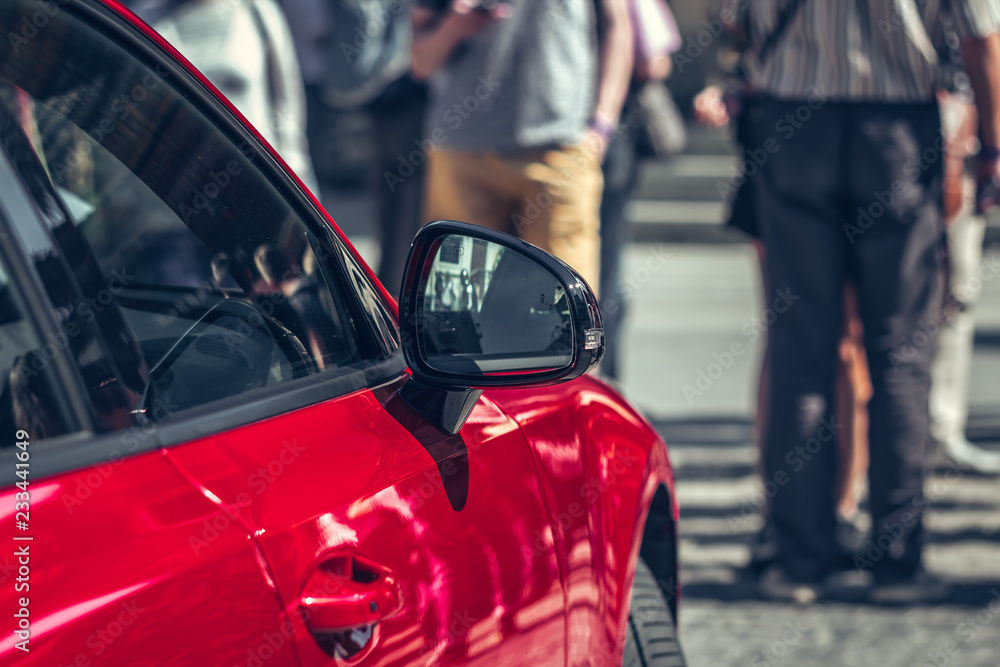 Selective and soft focus of side mirror and blurry red car on road with ...
