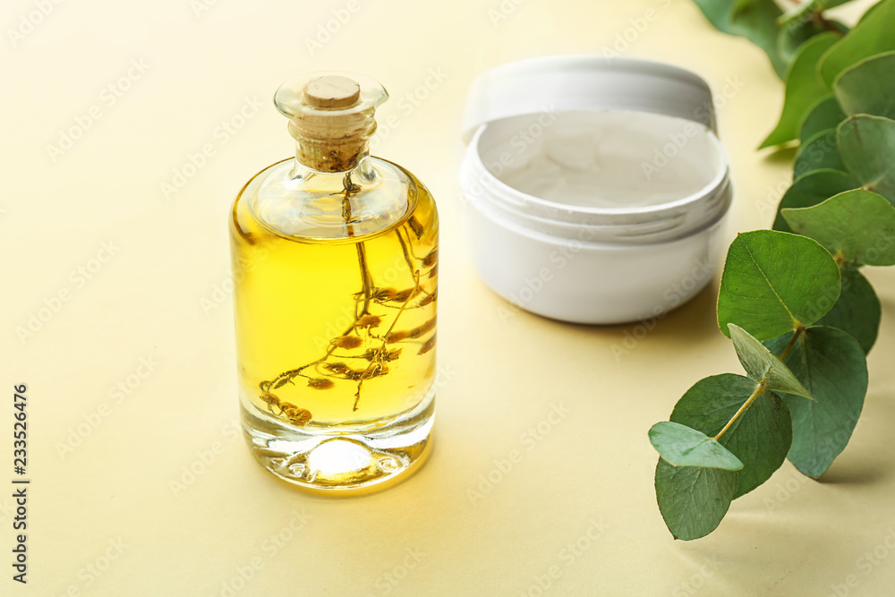 Cream and bottle of eucalyptus essential oil on color background Stock ...