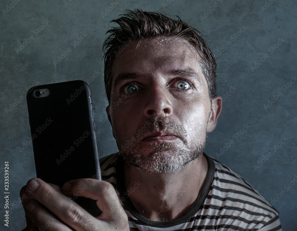 young weird and crazy mobile phone addict man using cell compulsively ...