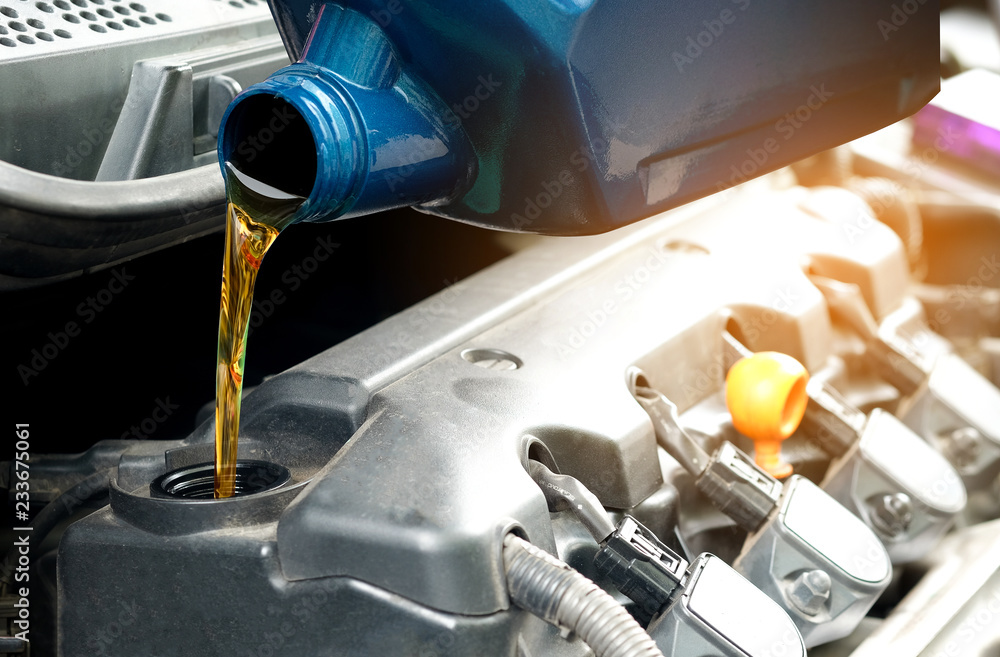 Refueling and pouring oil quality into the engine motor car ...