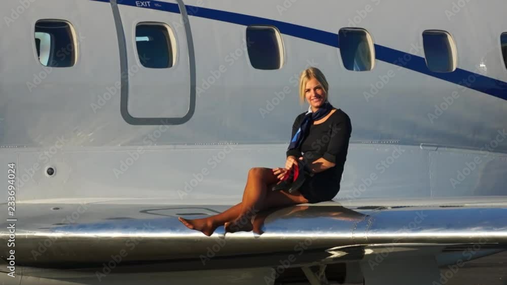 A playful flight attendant walks on the wing of an aircraft. vídeo de ...