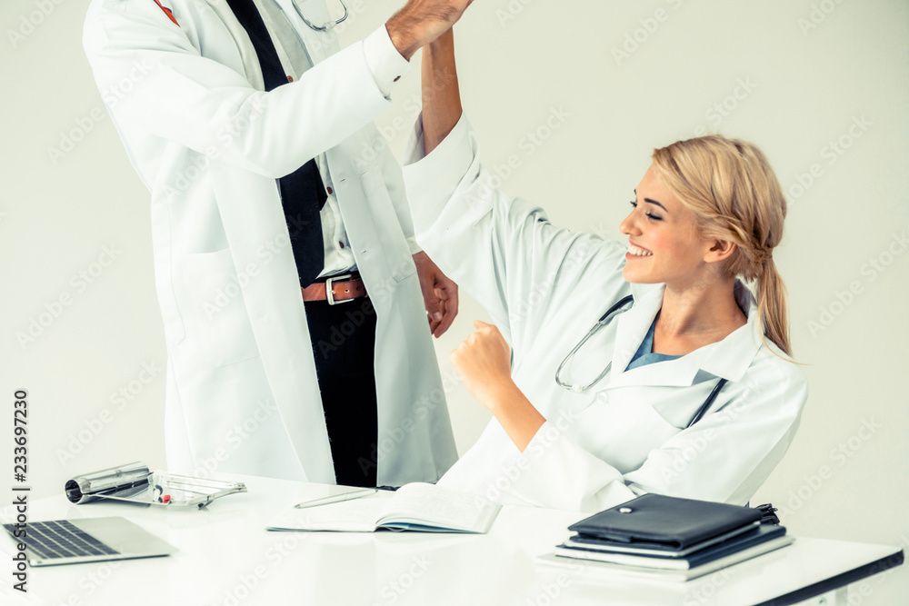 Happy successful doctor celebrates victory in hospital office with ...