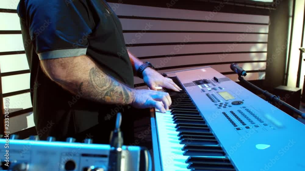 Gimbal shot of a Hispanic Rocker playing an electric keyboard on stage ...