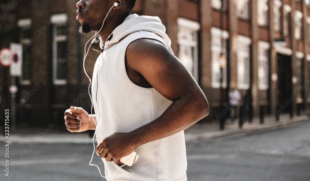 Athletic man running with earphones Stock Photo | Adobe Stock
