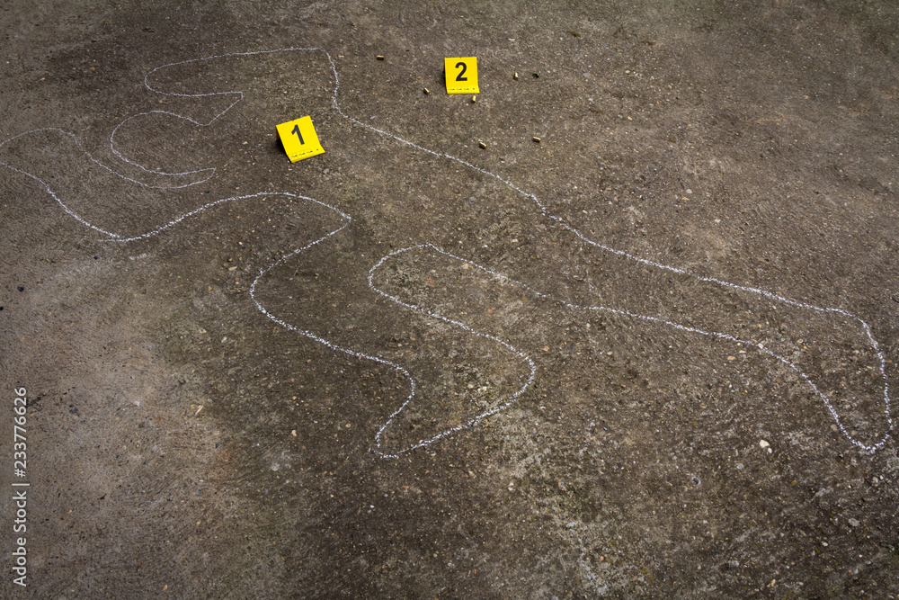 Crime scene. Shape of body on concrete texture. Bullet shell next to ...