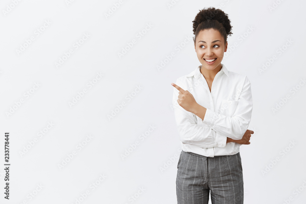 Dreamy female dark-skinned employee looking through window, wanting go ...