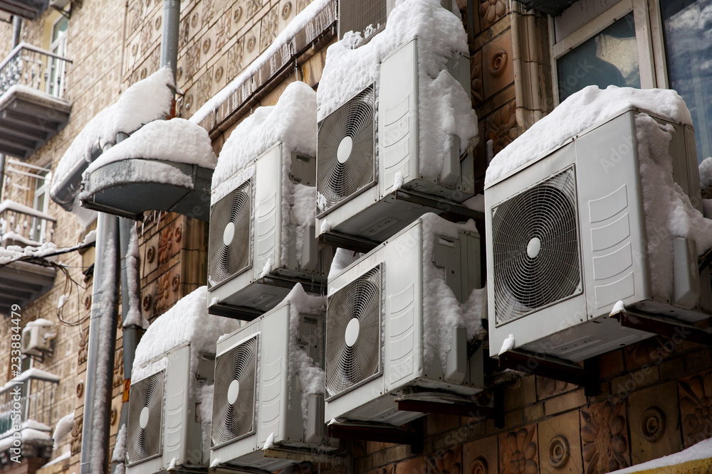 The air conditioning system surrounded by snow and ice, close-up, as a ...