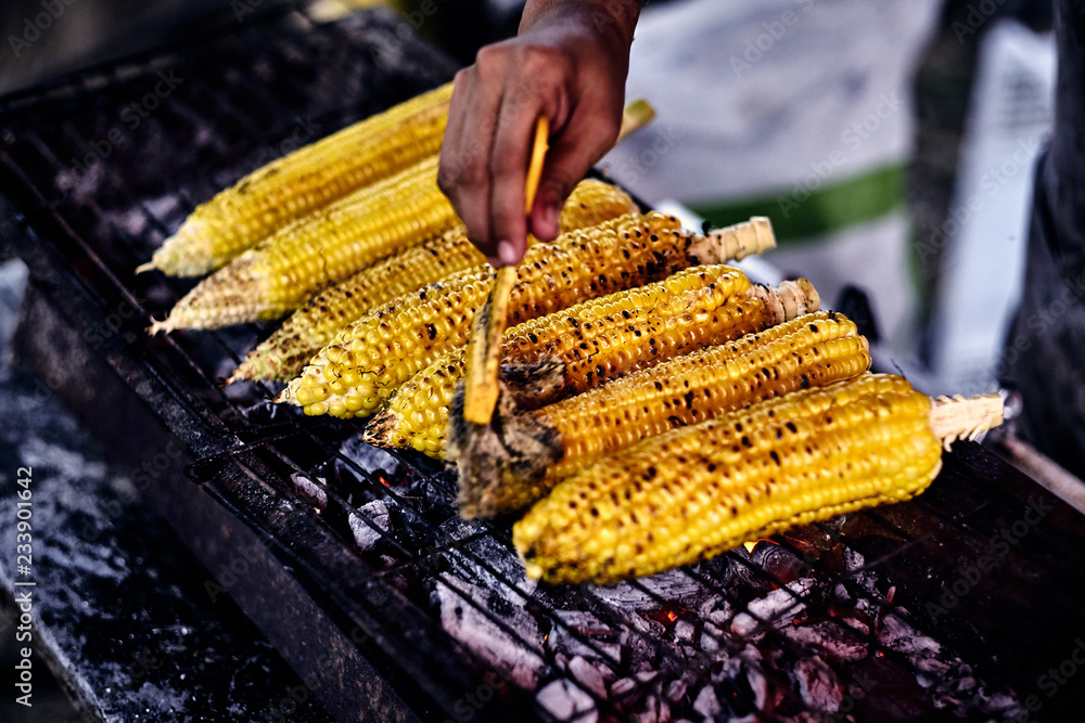 Corn cobs on the grill. Close up image with corns and hands. Asian ...