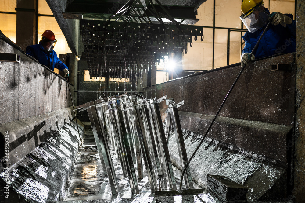 People at work galvanizing metallic structures in a zinc bath Stock ...