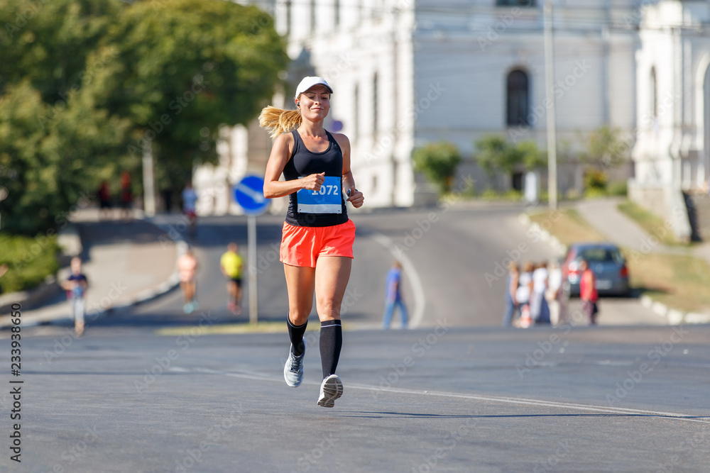 Young sporty woman running in marathon competition Stock Photo | Adobe ...