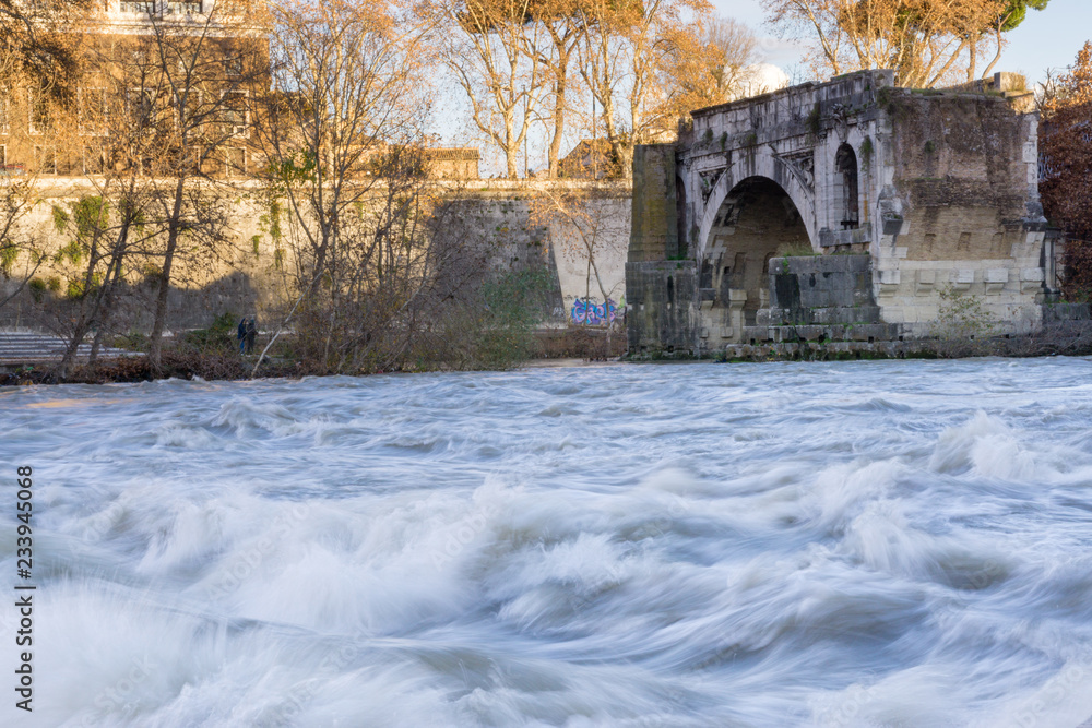 long exposure of the Tiber river with rough water and in the background ...