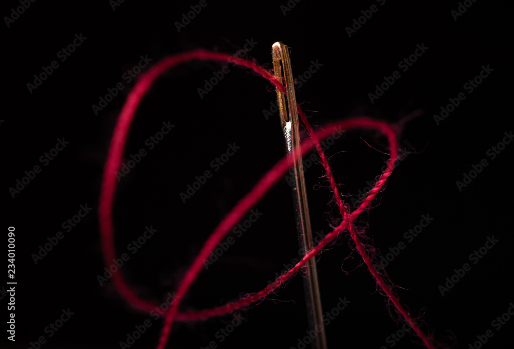 needle and thread on a black background Stock Photo | Adobe Stock