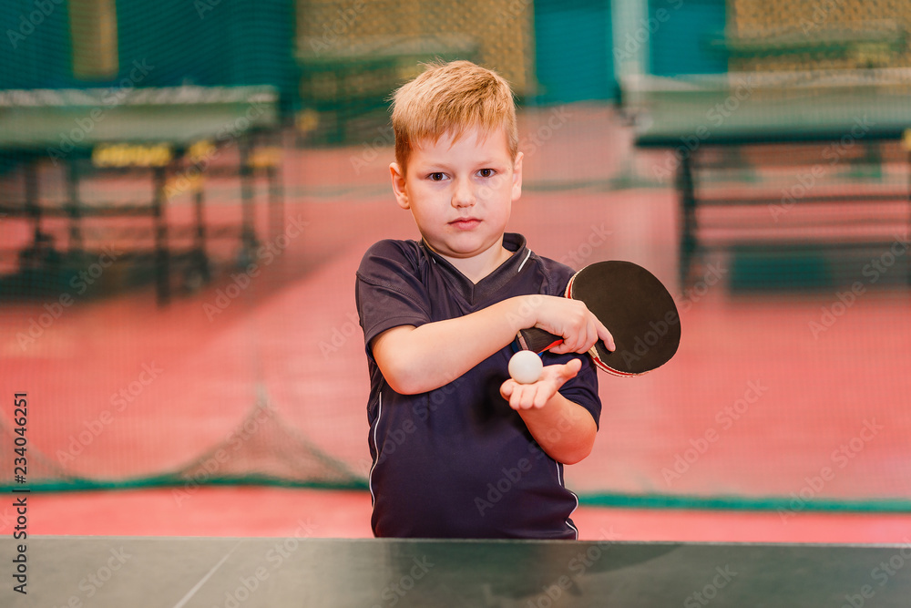 child table tennis player holding a ball and a rocket in the gym Stock ...
