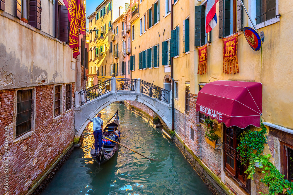 Narrow canal with gondola and bridge in Venice, Italy. Architecture and ...