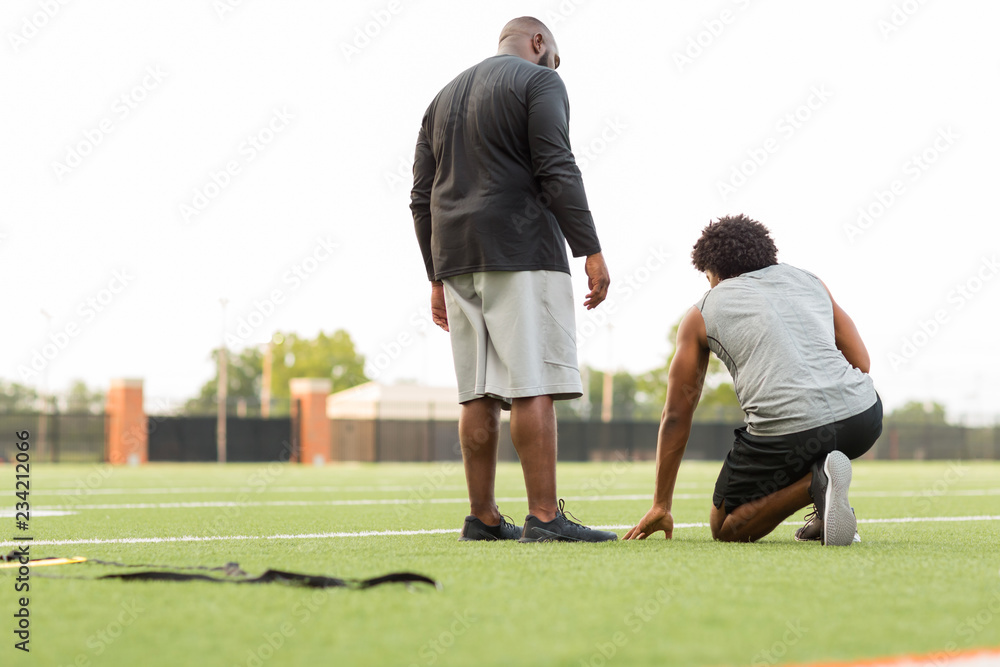 American Football coach training a young athlete. Stock Photo | Adobe Stock